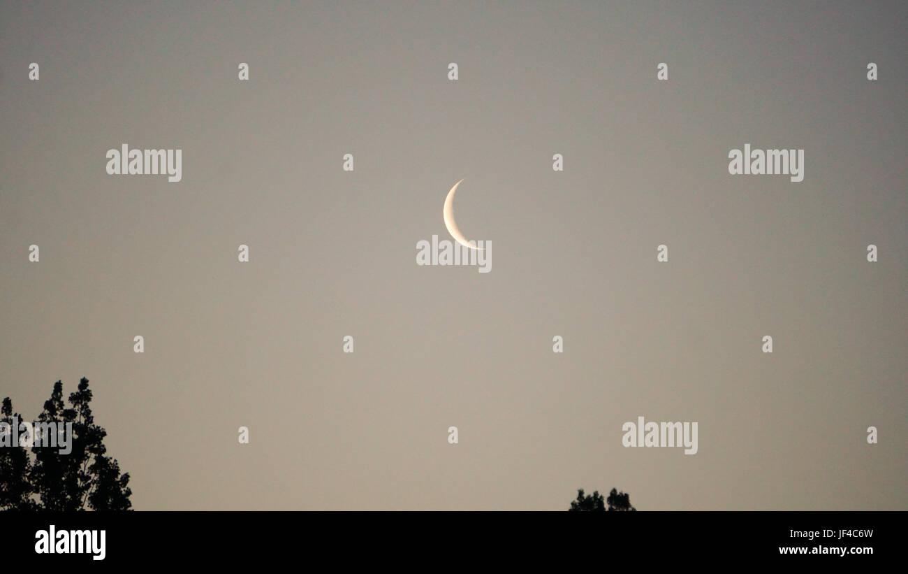 The Crescent moon hanging in the morning sky Stock Photo - Alamy