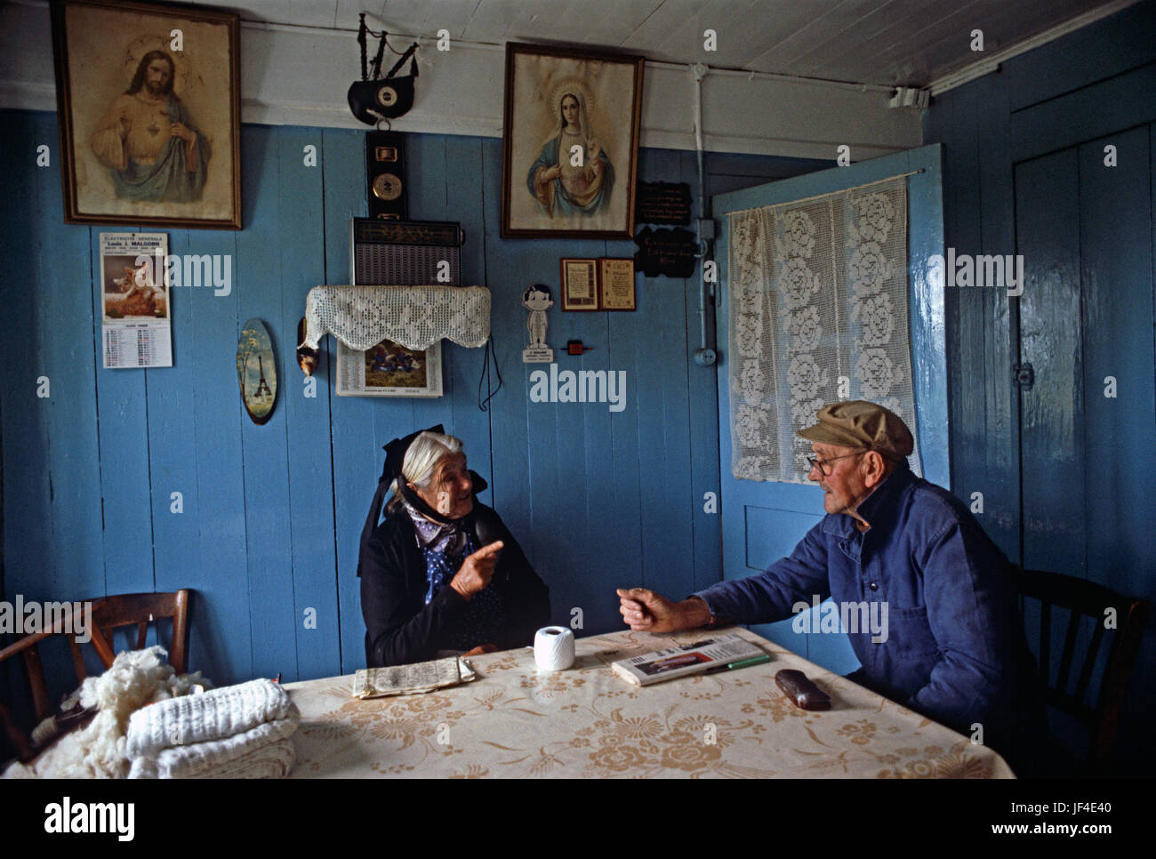 Old Breton couple in working clothes in traditional house on Island of ...