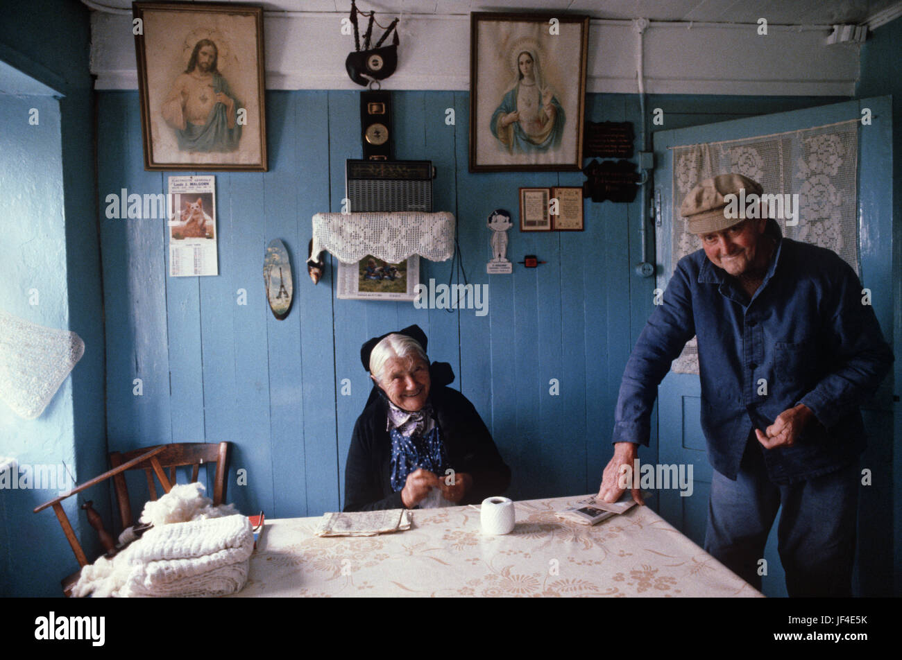 Old Breton couple in working clothes in traditional house on Island of ...