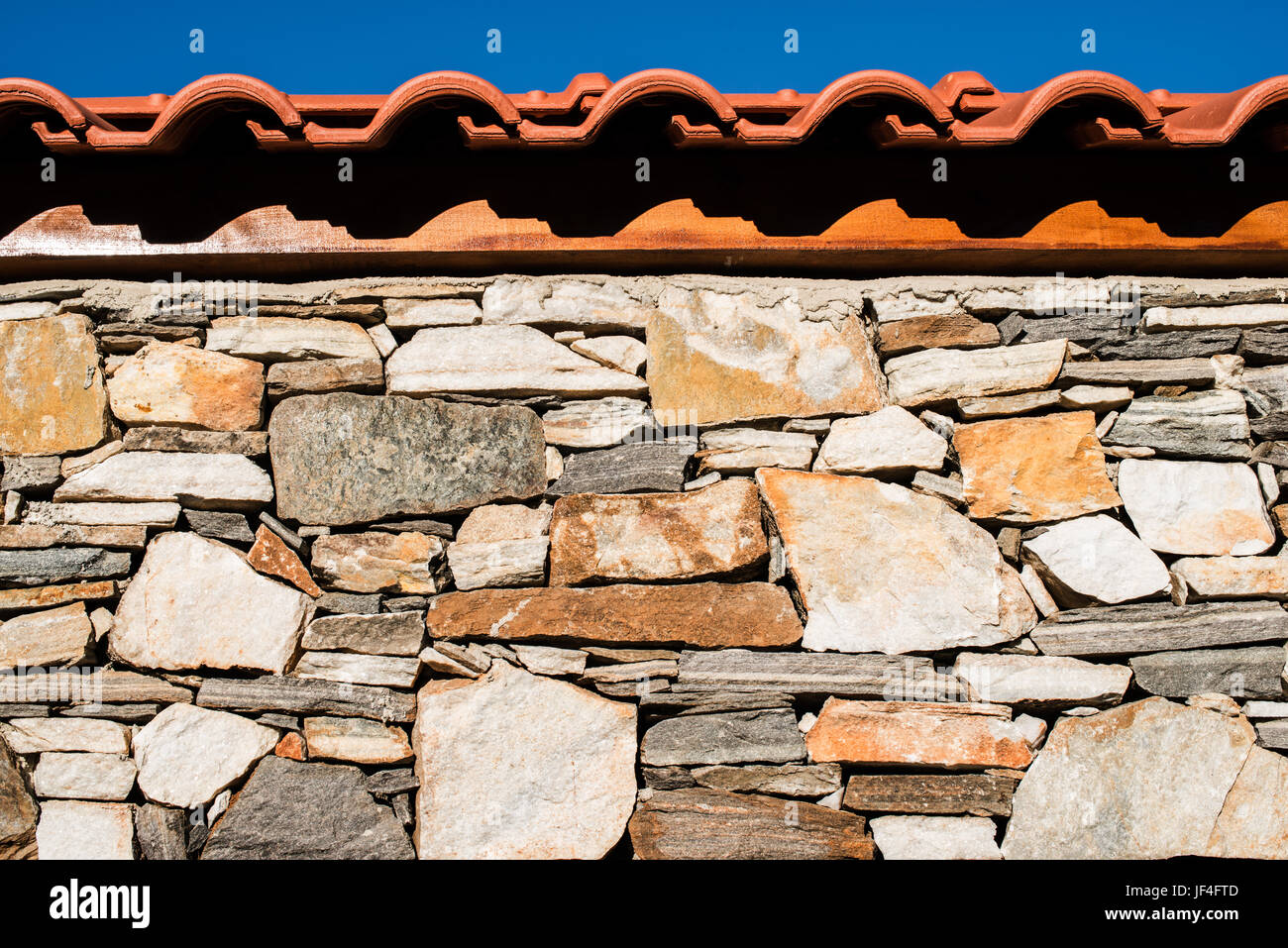 Wall built of stones. Sun light Stock Photo - Alamy