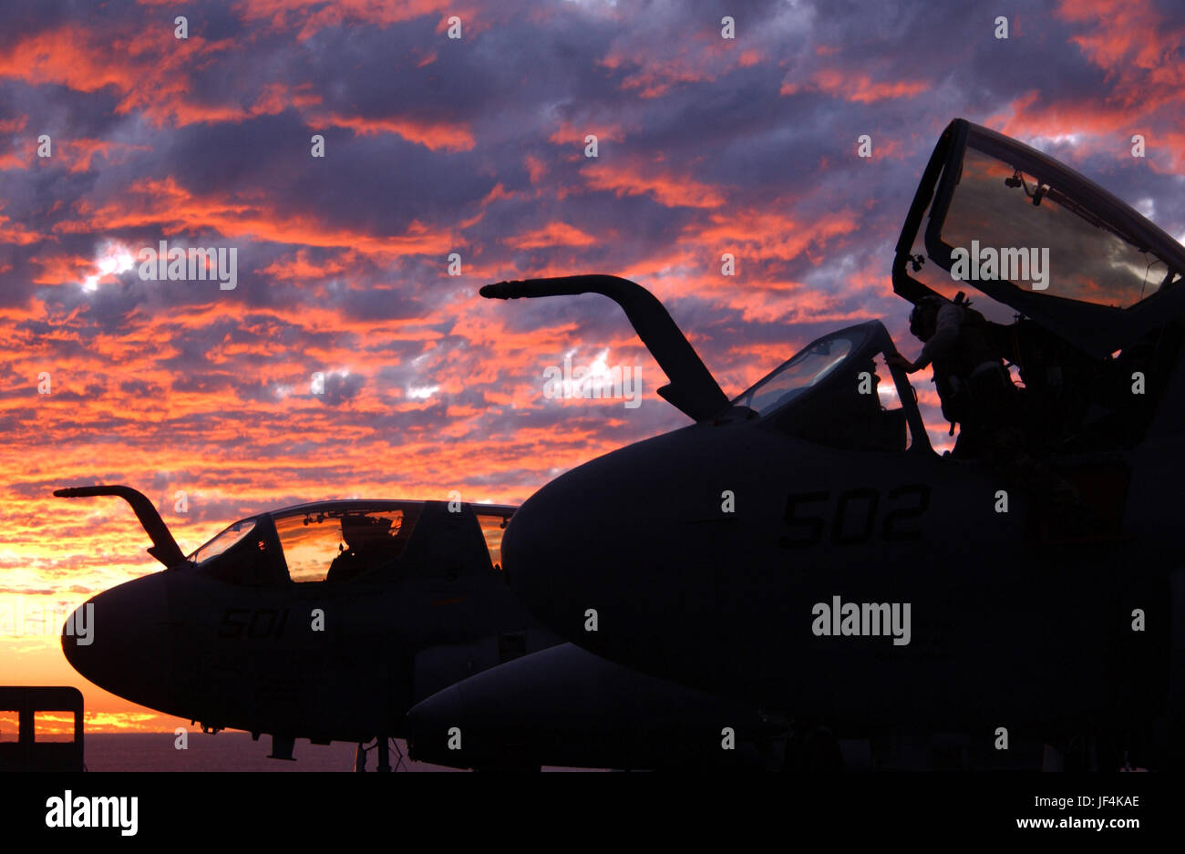 Personnel prepare EA-6B Prowlers for night flight operations as the sun ...