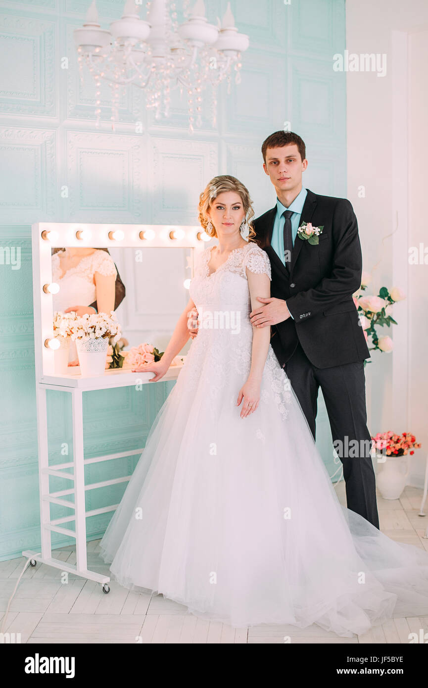 Happy couple. Wedding photo shoot in the white studio with wedding ...