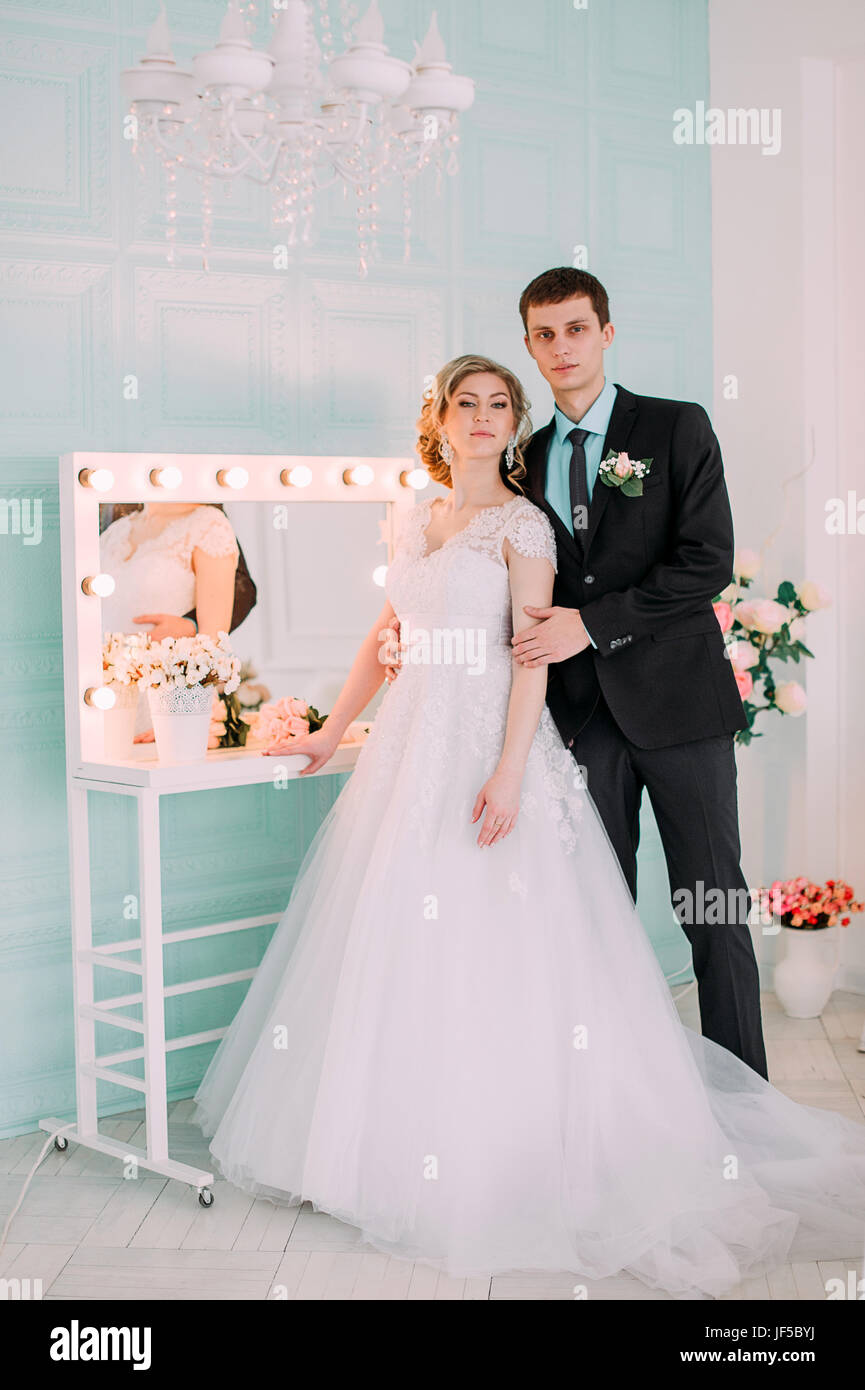 Happy couple. Wedding photo shoot in the white studio with wedding ...