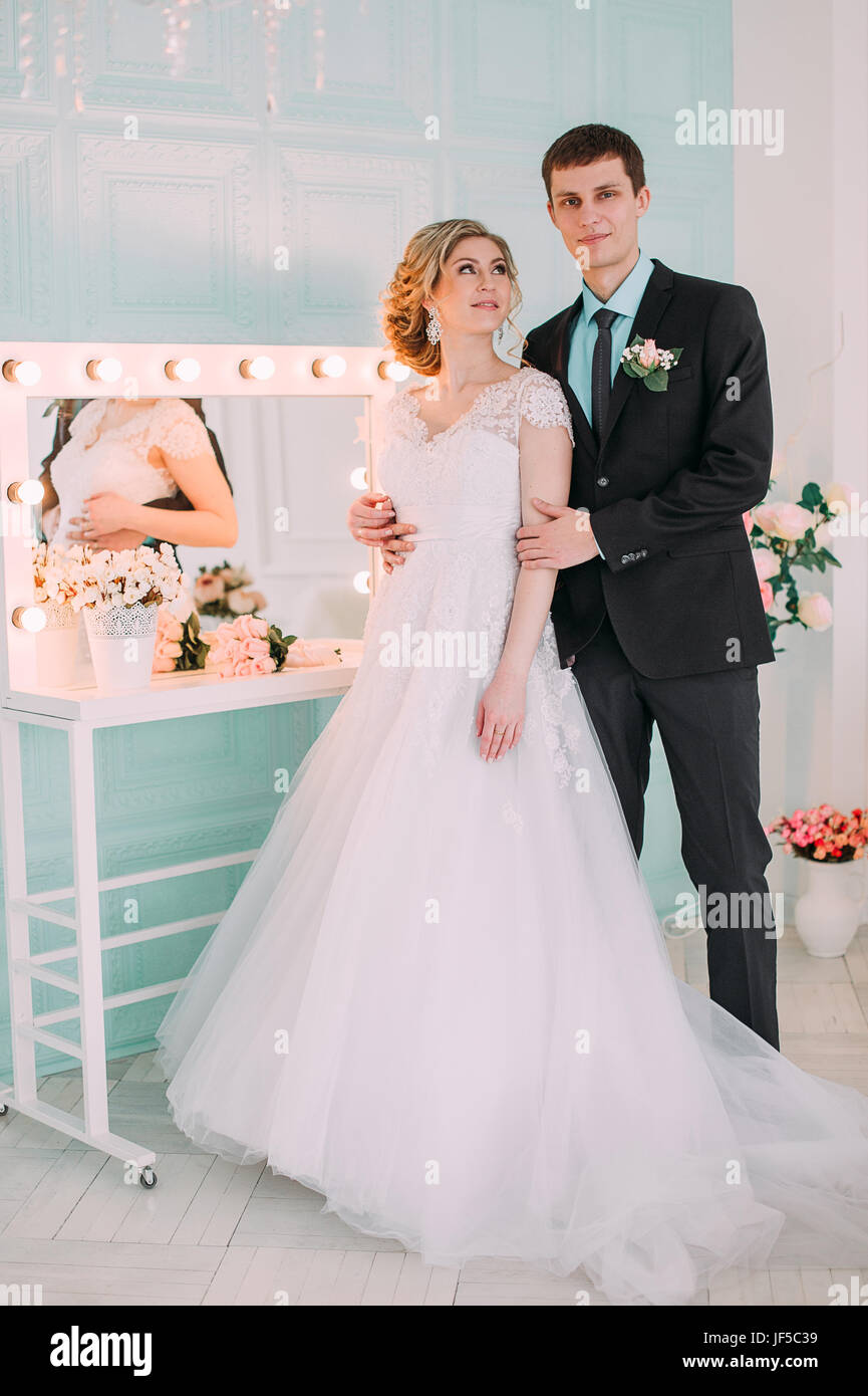Happy couple. Wedding photo shoot in the white studio with wedding ...