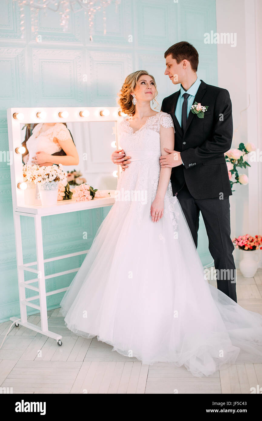 Happy couple. Wedding photo shoot in the white studio with wedding ...