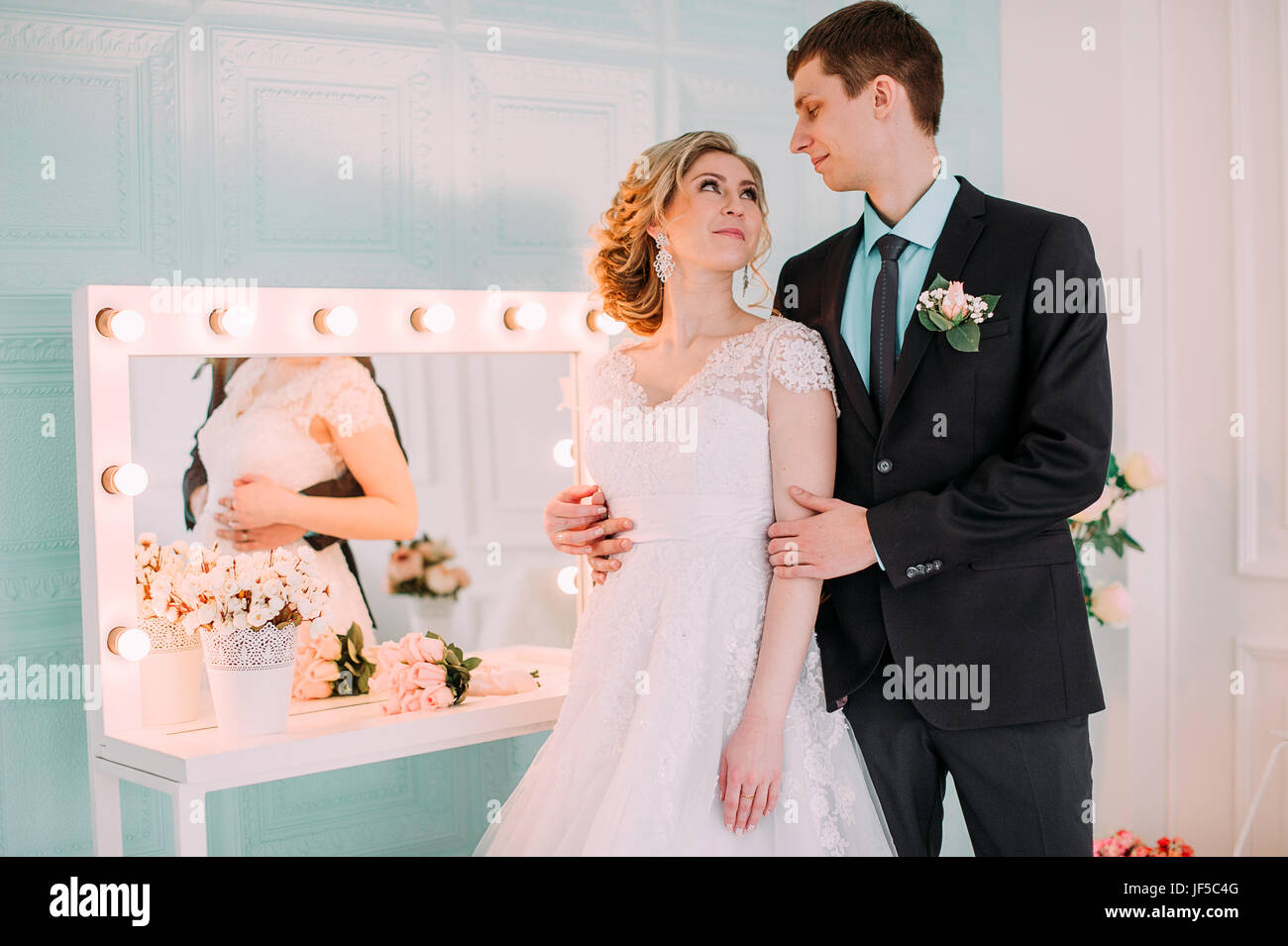 Happy couple. Wedding photo shoot in the white studio with wedding ...