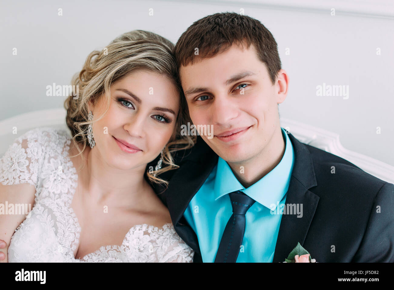 Happy couple. Wedding photo shoot in the white studio with wedding ...