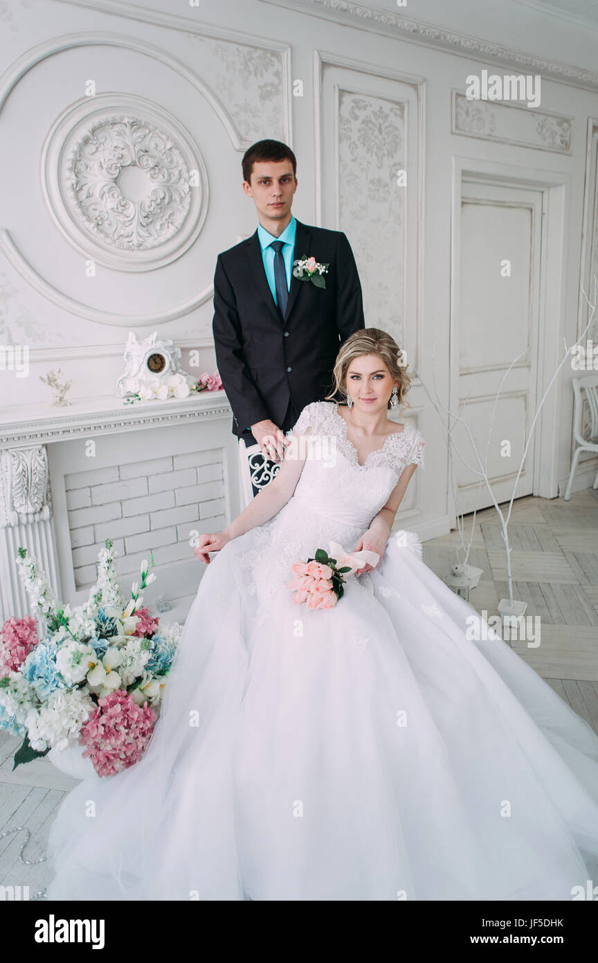 Happy couple. Wedding photo shoot in the white studio with wedding ...