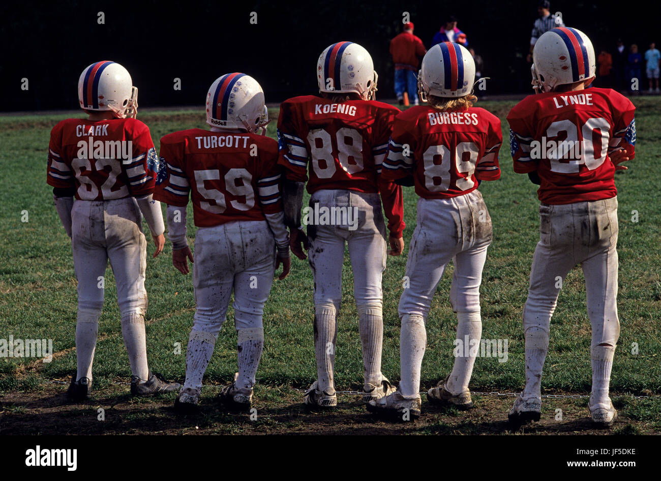 Football team along sidelines during game with backs to camera waiting ...