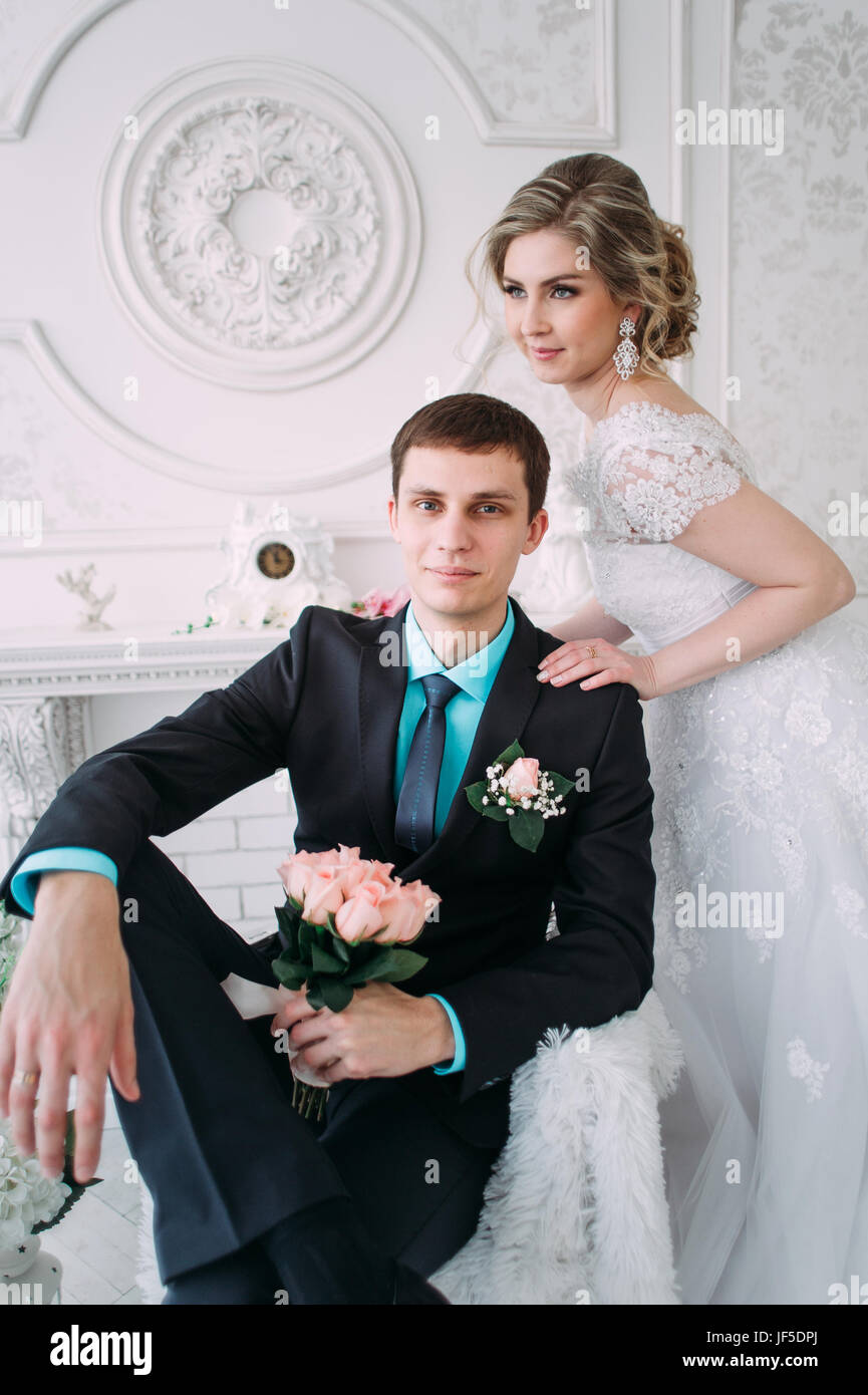 Happy couple. Wedding photo shoot in the white studio with wedding ...
