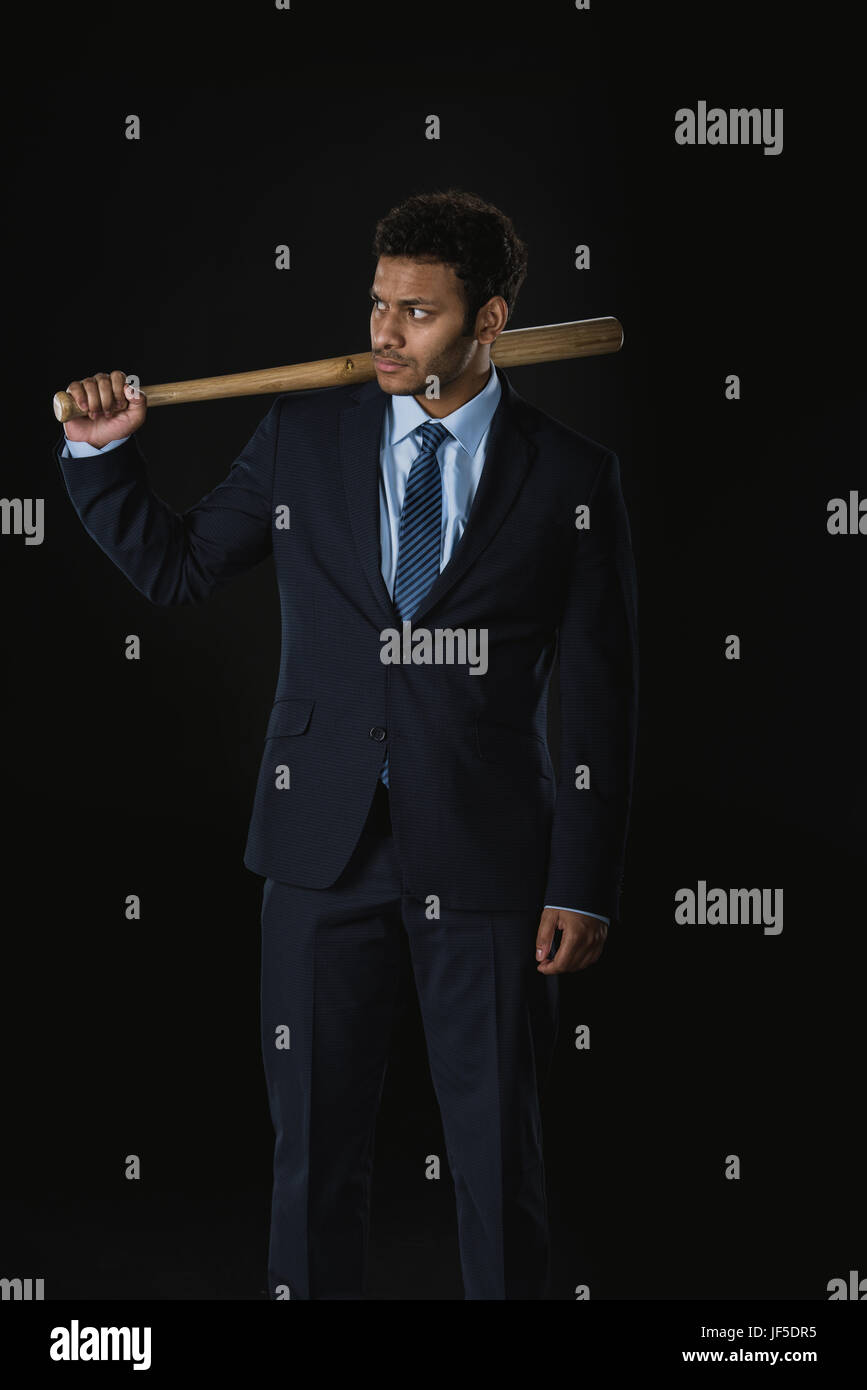 Young serious businessman holding baseball bat and looking away Stock ...