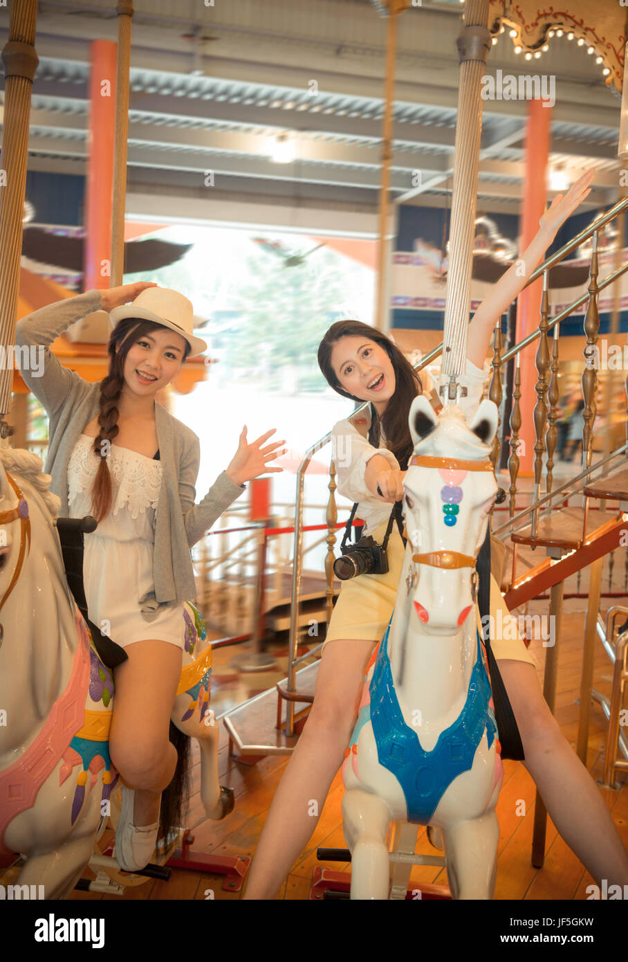 asian pretty girls going to the amusement park playing merry-go-round ...