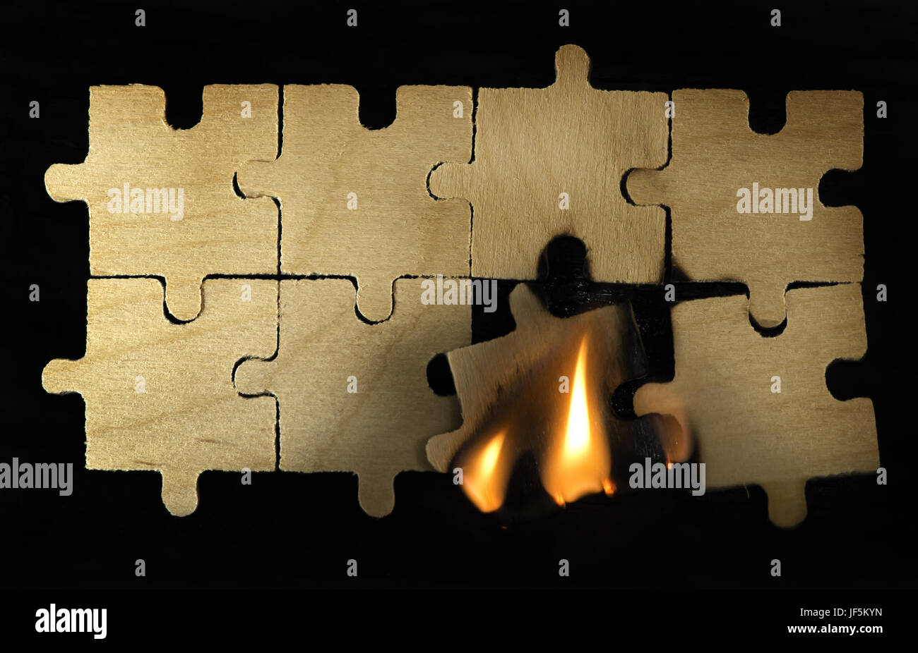 Burning wooden puzzle on dark background Stock Photo - Alamy