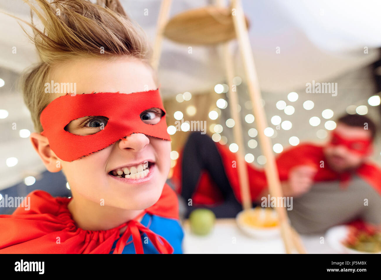 Close-up portrait of excited little boy in superhero costume looking at ...
