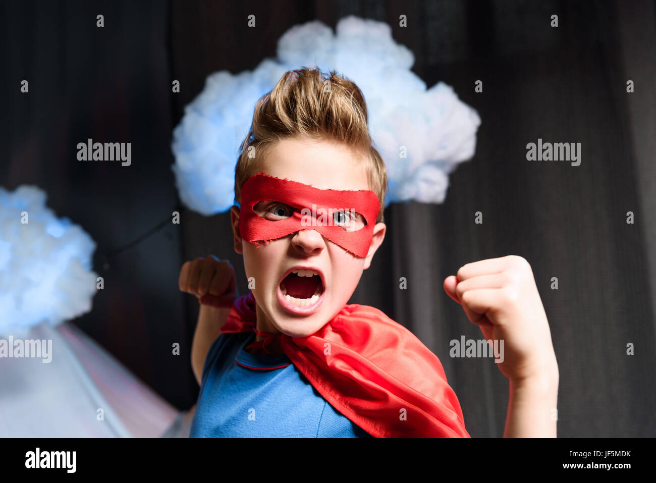 boy in red superhero costume with fighting gesture screaming and ...