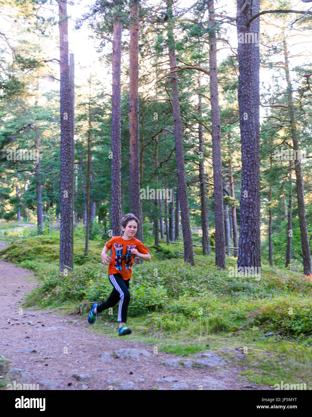 Boy running in forest Stock Photo - Alamy