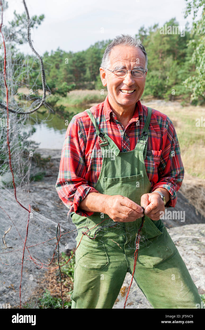 Old man repairs fishing hi-res stock photography and images - Alamy