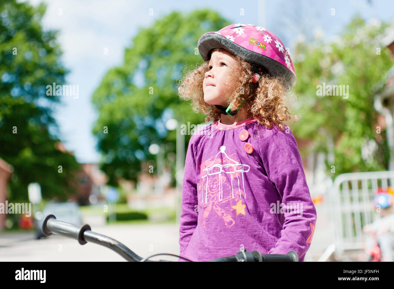 Girl in safety helmet standing in street Stock Photo - Alamy