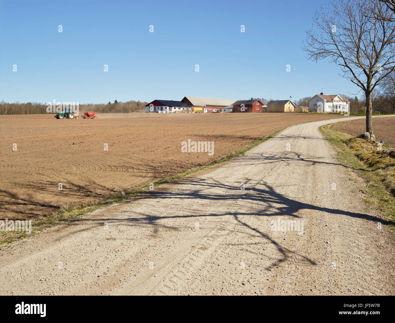 Dirt track, tractor on field on background Stock Photo - Alamy