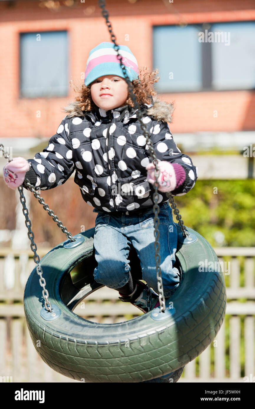 Girl swinging on tire Stock Photo - Alamy