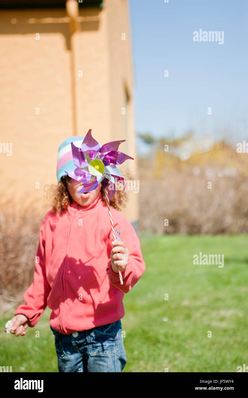 Girl holding pinwheel Stock Photo - Alamy