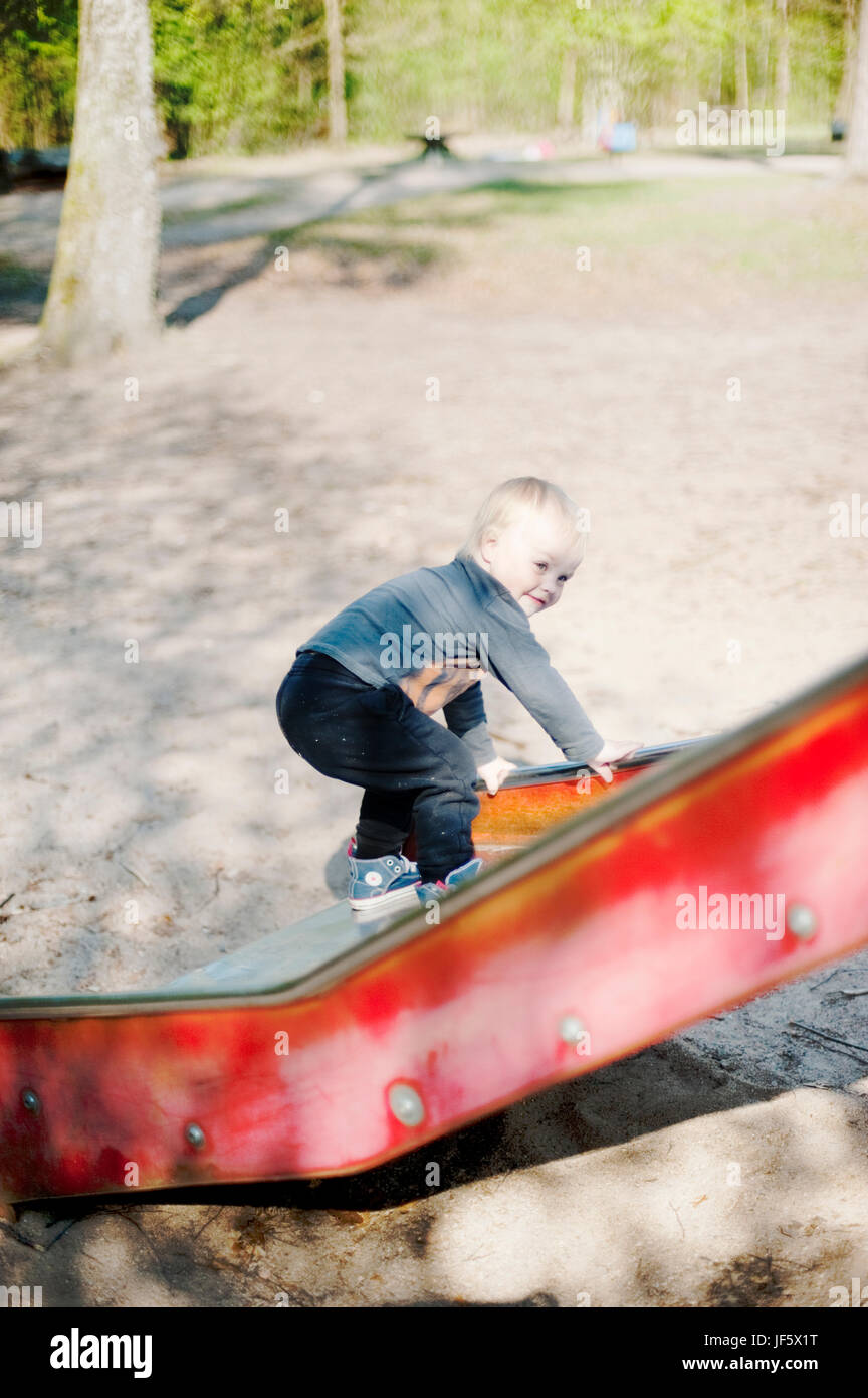 Boy on slide at playground Stock Photo - Alamy