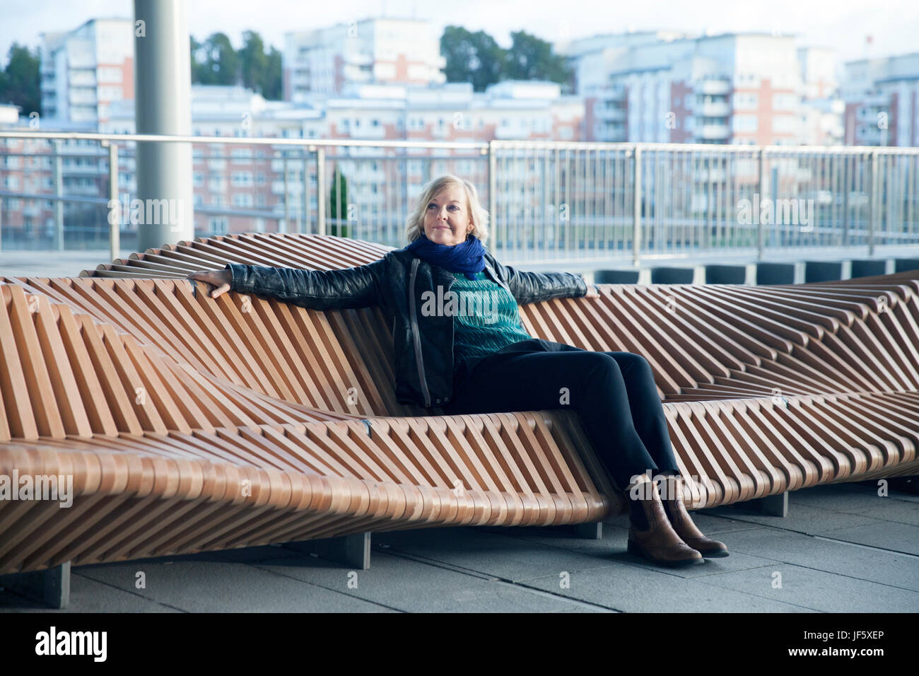 Woman sitting on modern bench Stock Photo - Alamy