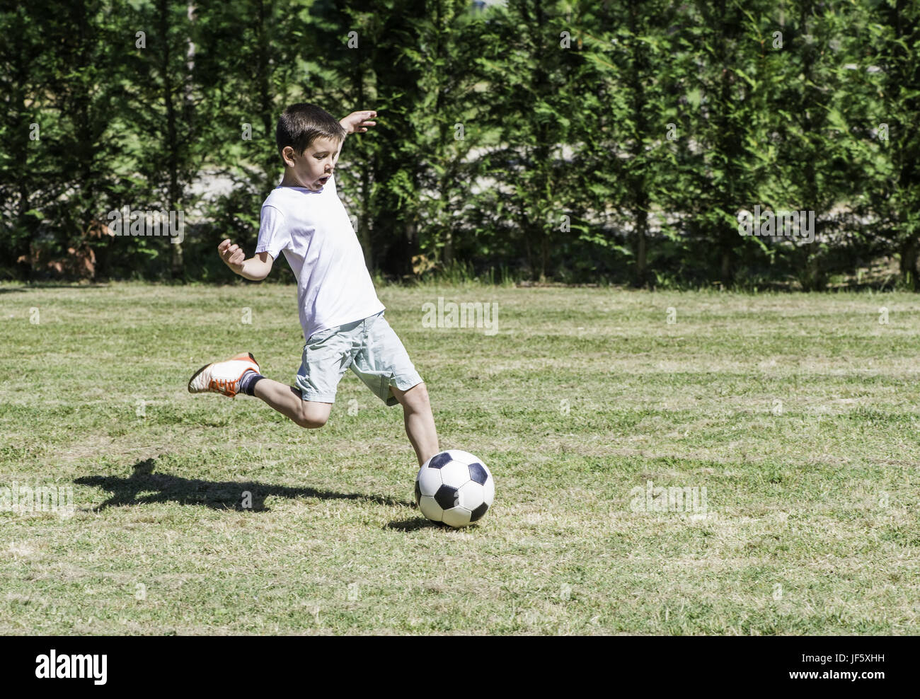 Child playing football in a stadium Stock Photo - Alamy