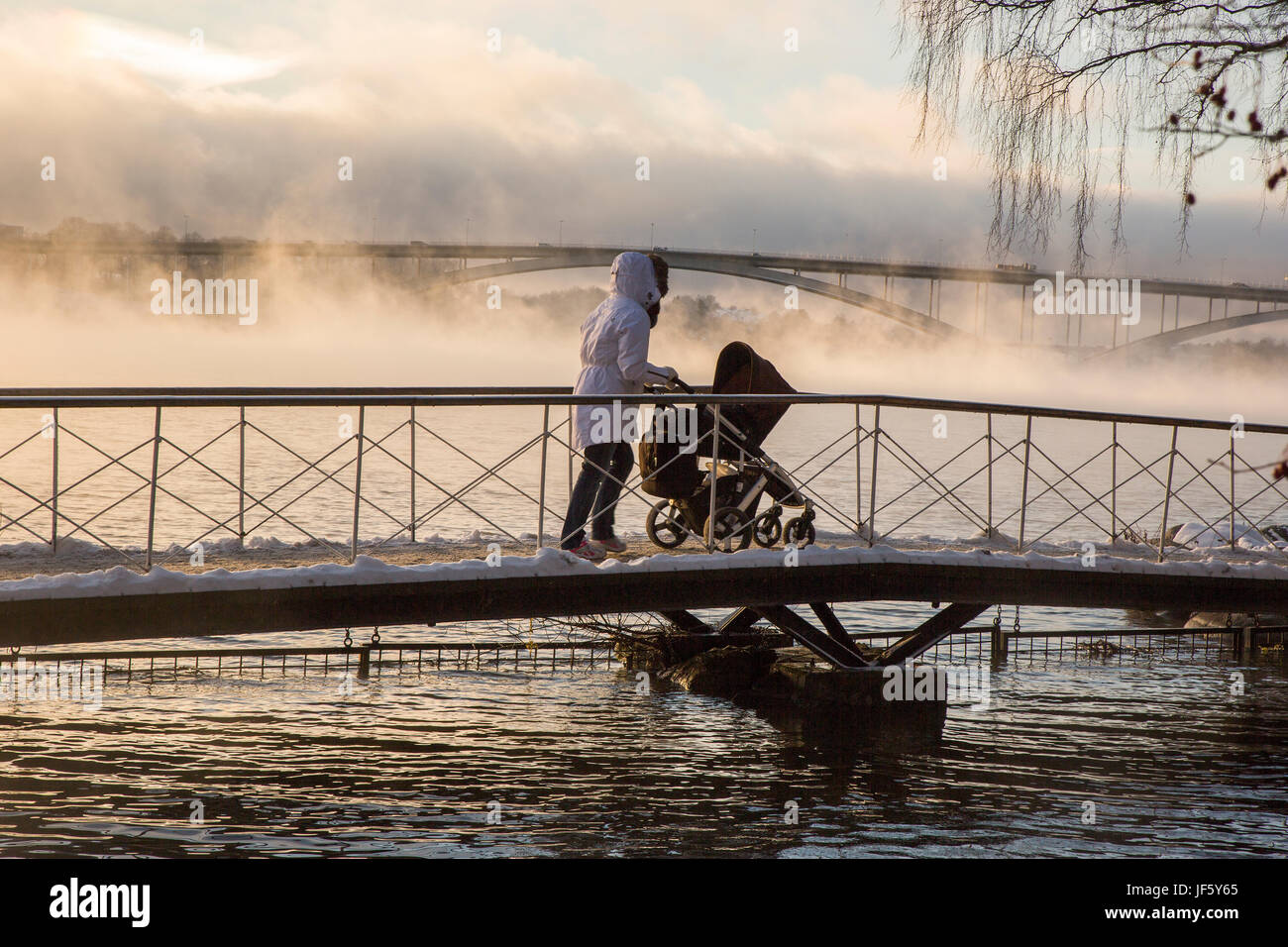 Woman with pram crossing footbridge Stock Photo - Alamy