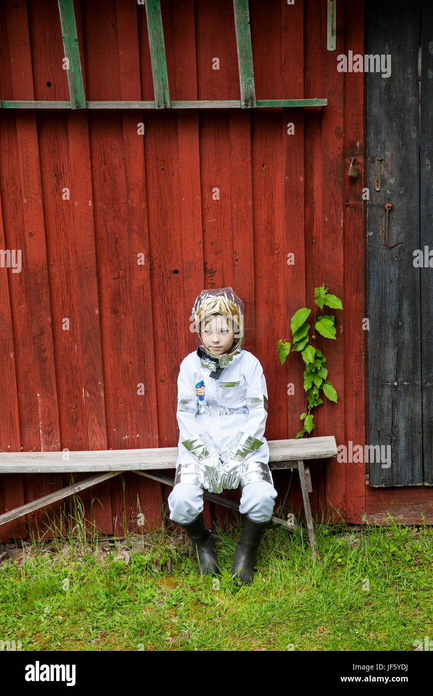 Boy wearing knight costume sitting on bench Stock Photo - Alamy