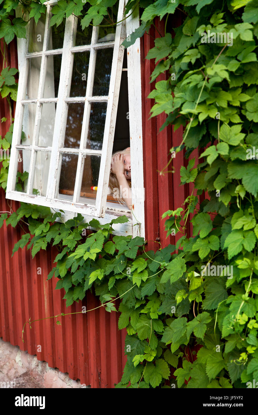 Girl looking through window Stock Photo - Alamy