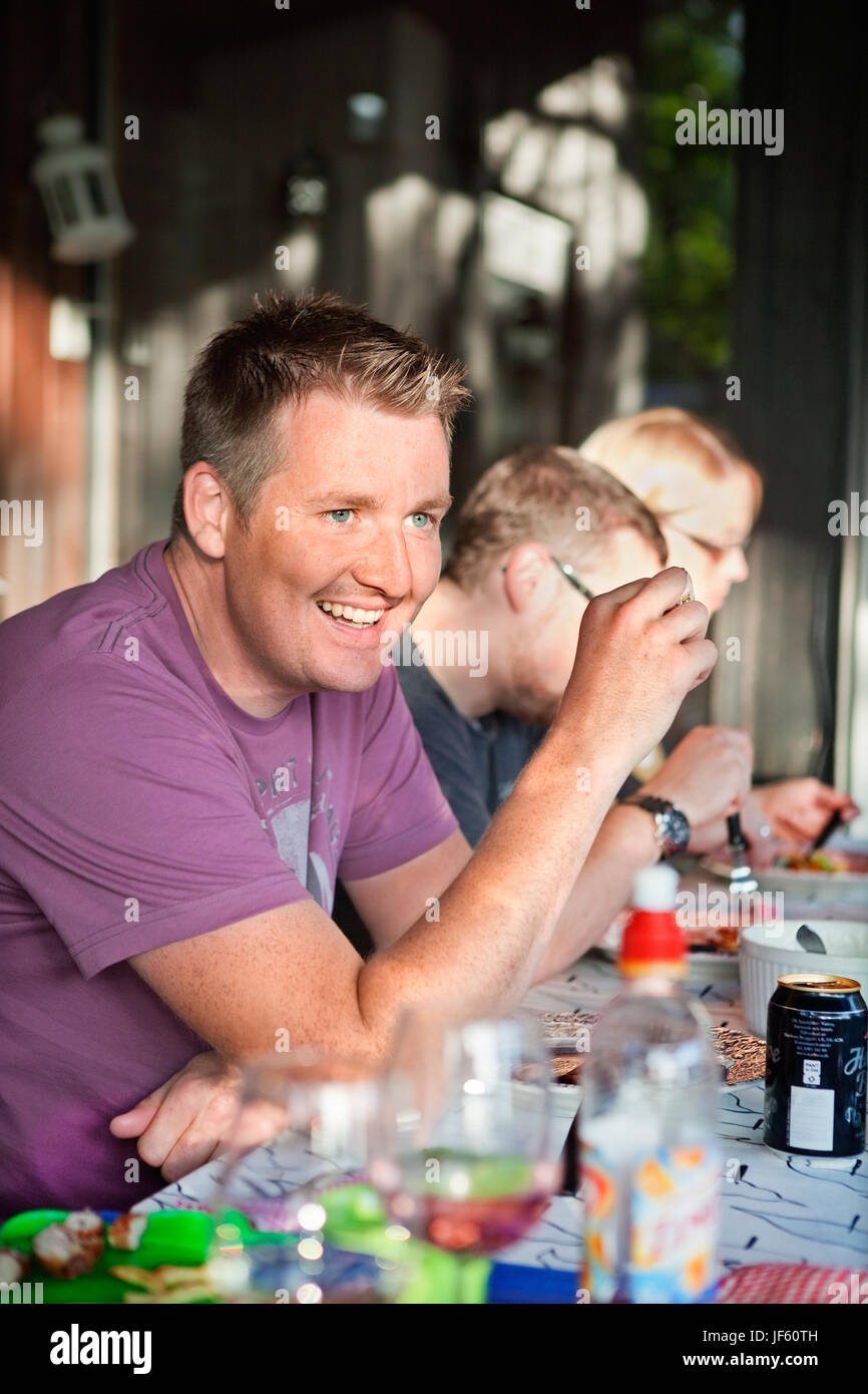 Smiling man sitting at dinner table Stock Photo - Alamy
