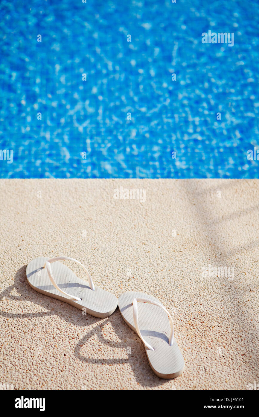 Pair of flip flops by pool Stock Photo - Alamy