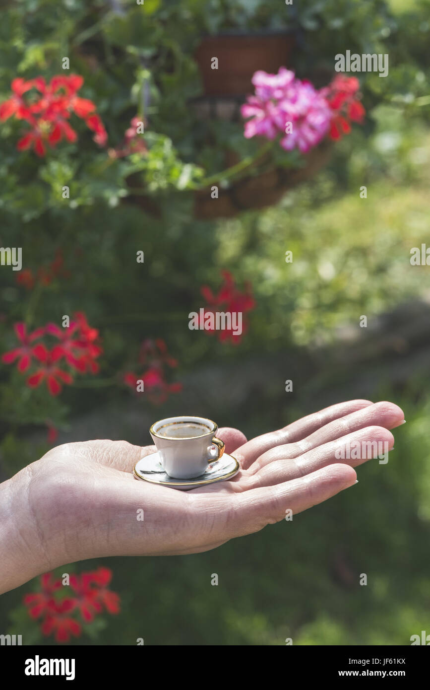 Hand hold very small cup of coffee Stock Photo - Alamy