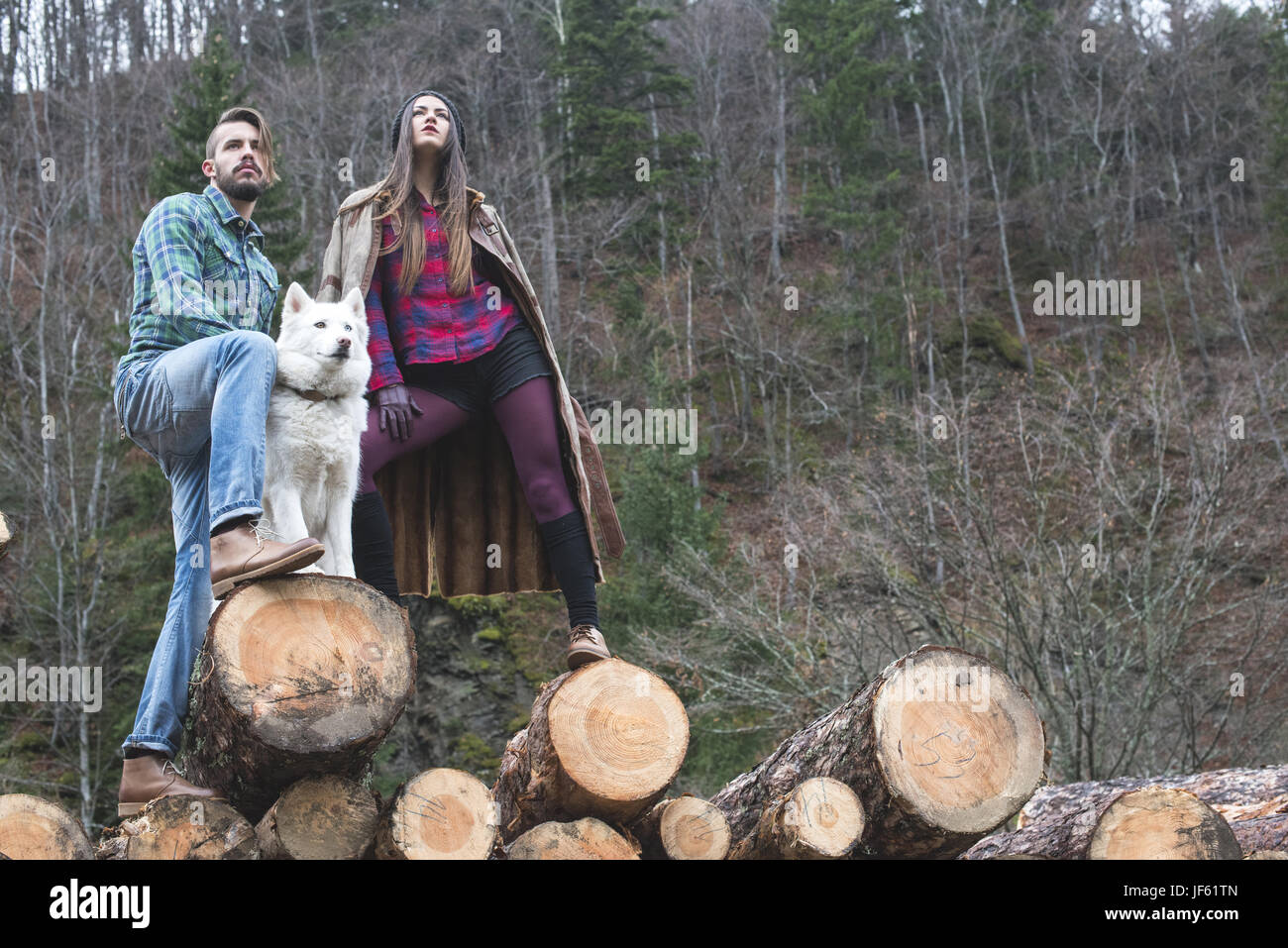 Young woman and men on wood logs Stock Photo - Alamy