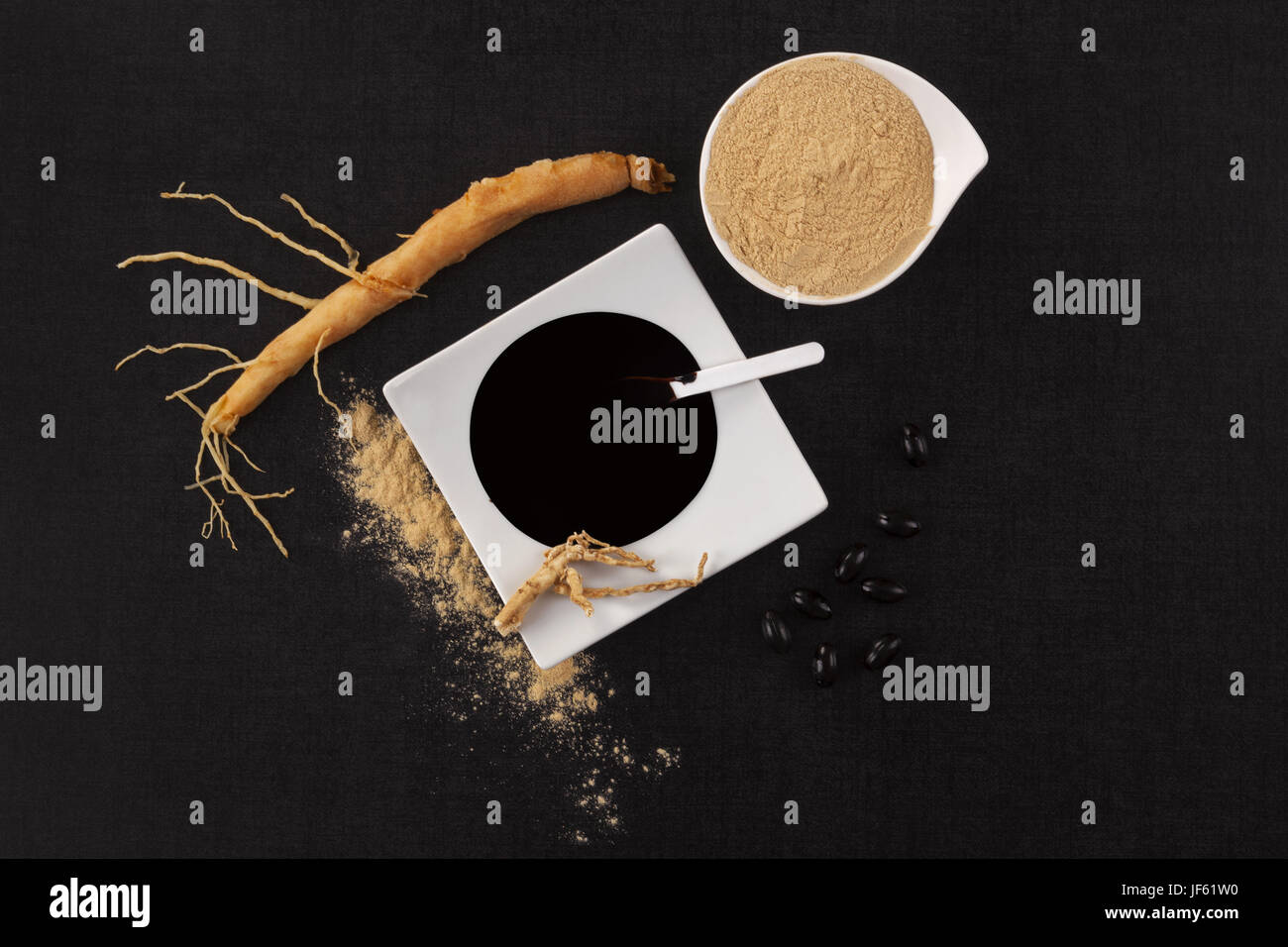 Ginseng root, extract, powder and pills on black background top view ...