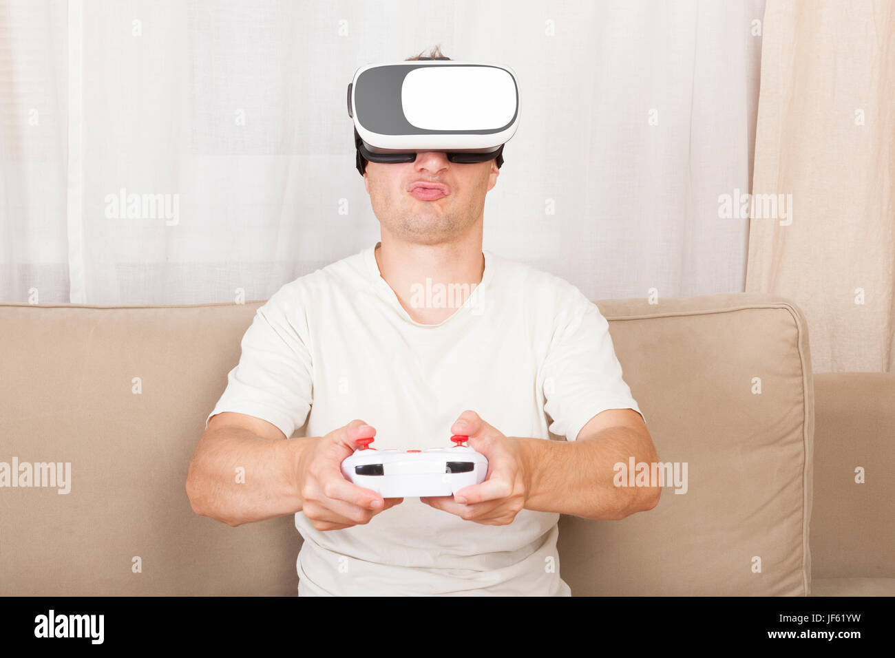 Handsome man with VR headset playing virtual reality in living room ...