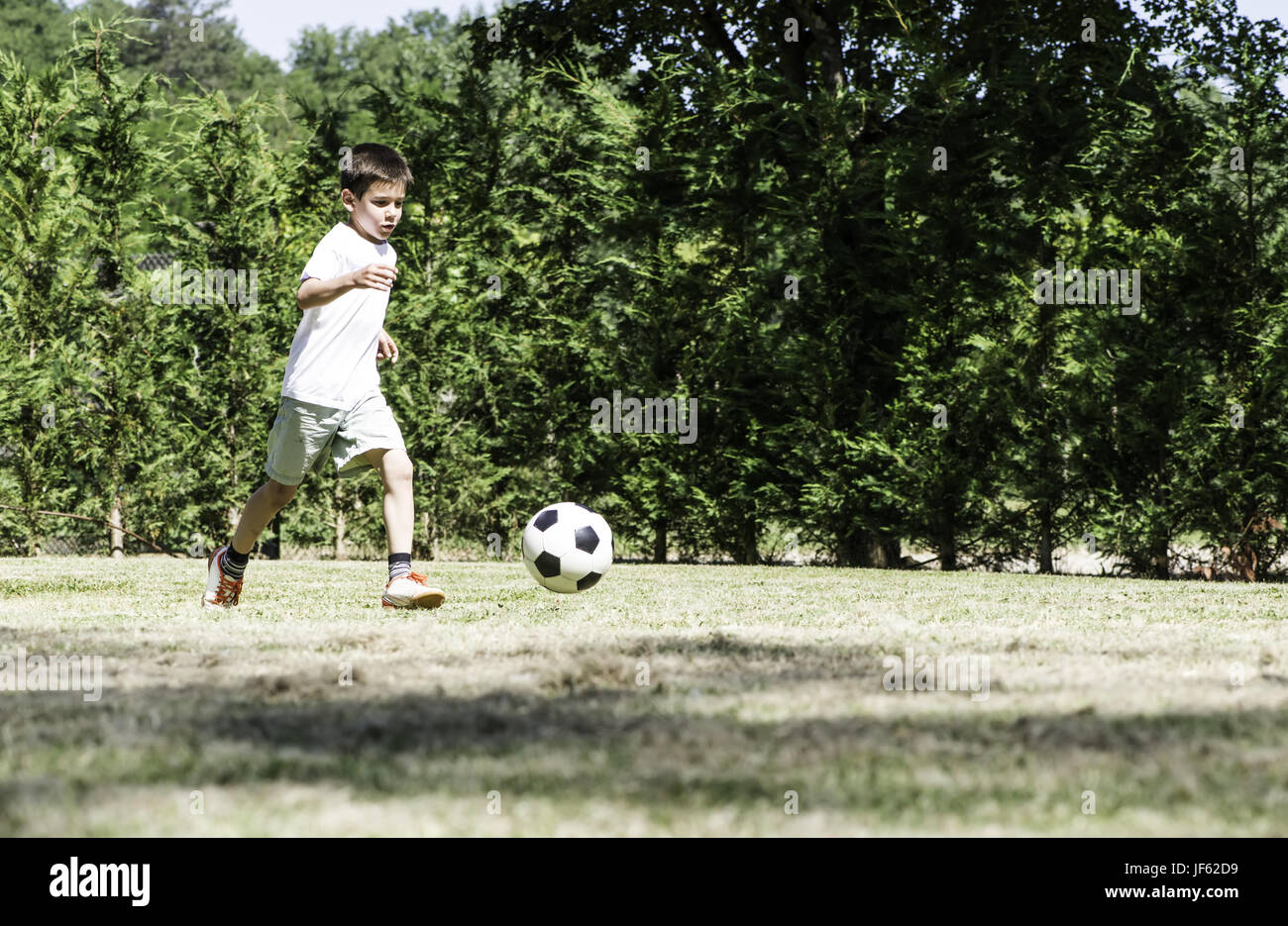 Child playing football in a stadium Stock Photo - Alamy
