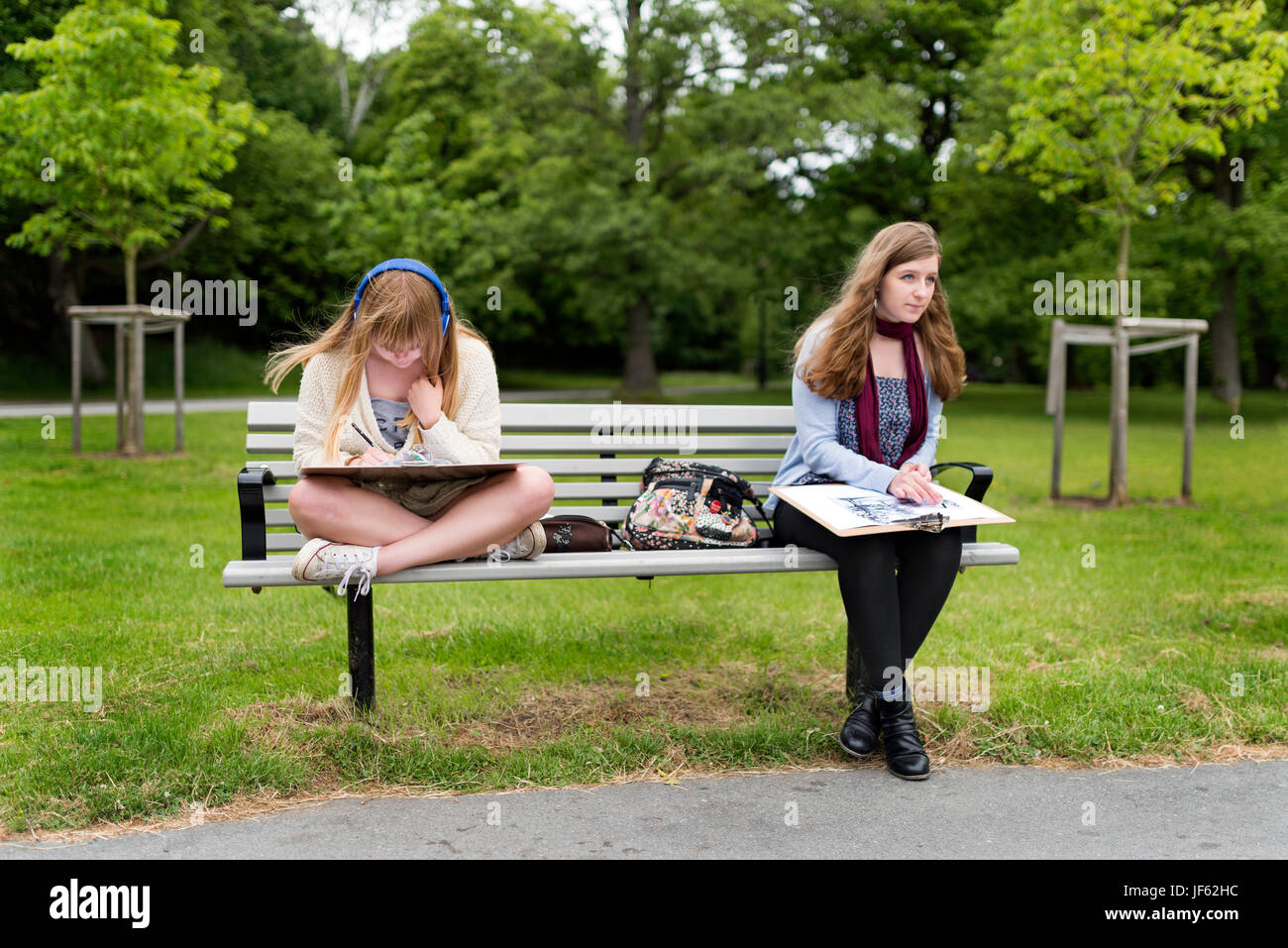 Teenage girls sitting on bench Stock Photo - Alamy