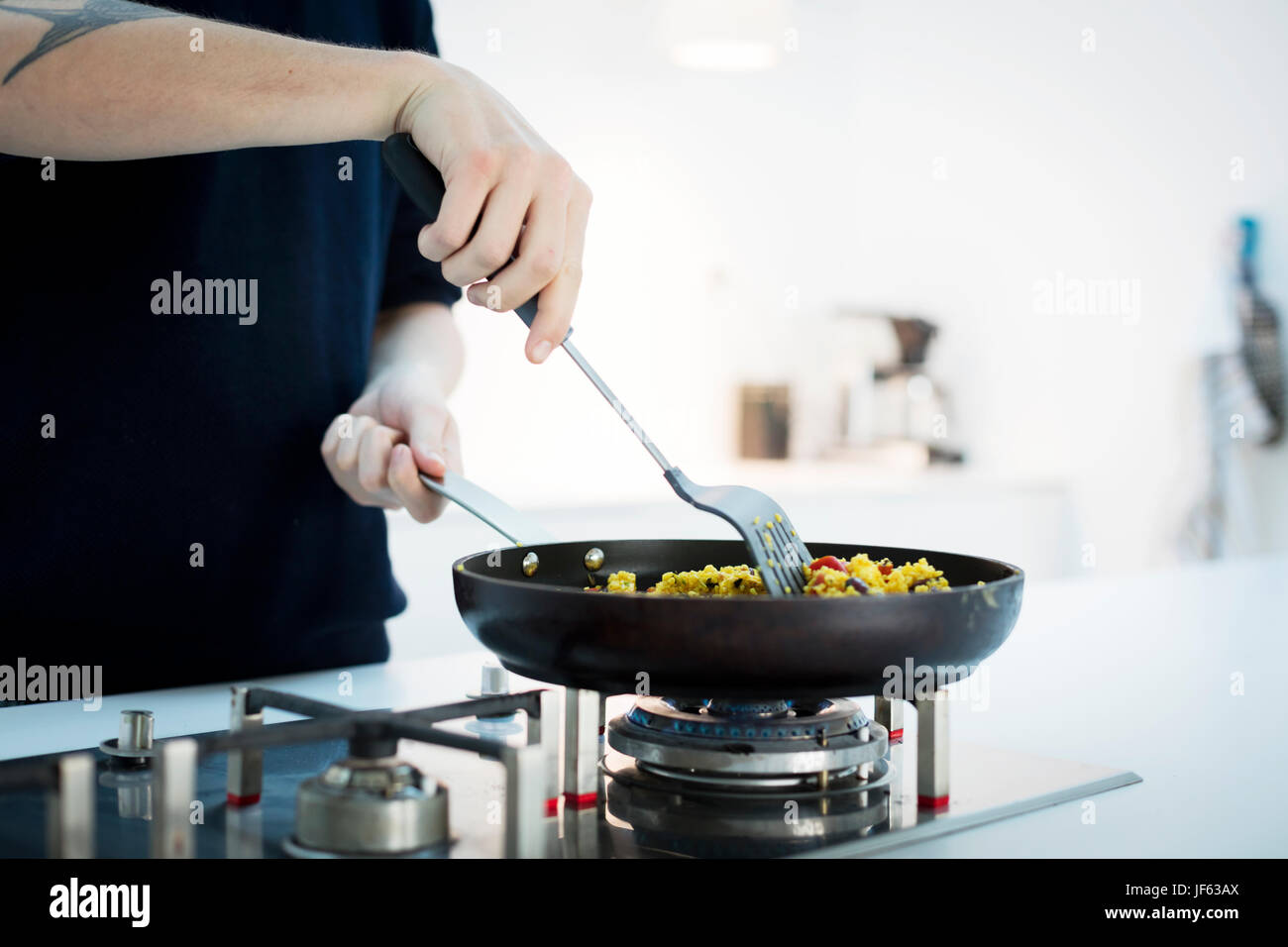 Mid section of man cooking food in kitchen Stock Photo - Alamy