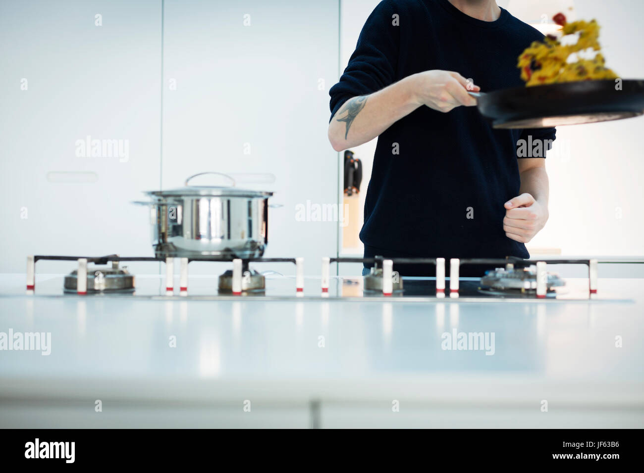 Mid section of man cooking food in kitchen Stock Photo - Alamy