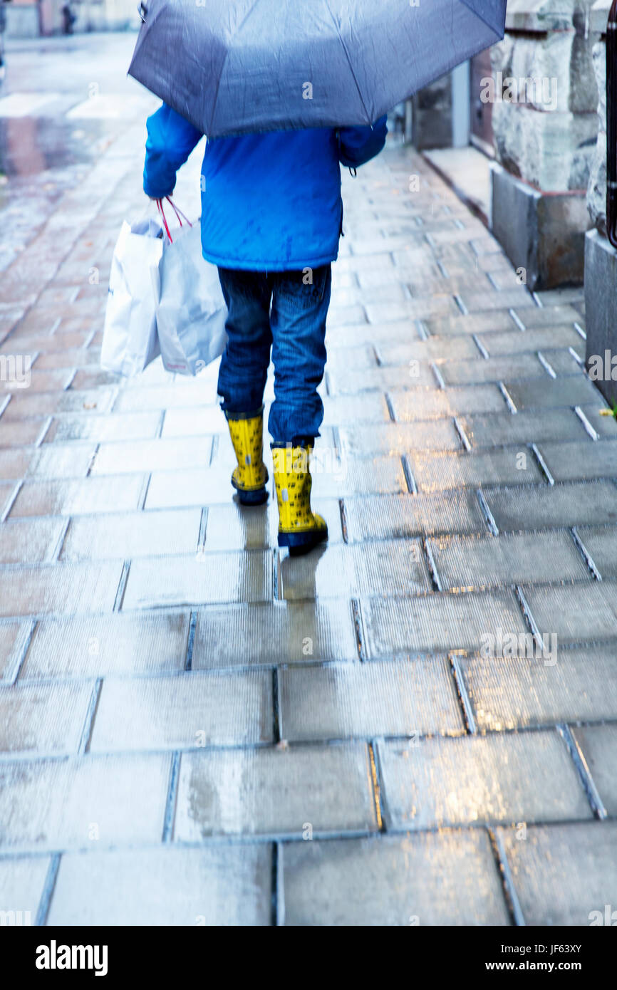 Child at rain carrying paper bags Stock Photo - Alamy