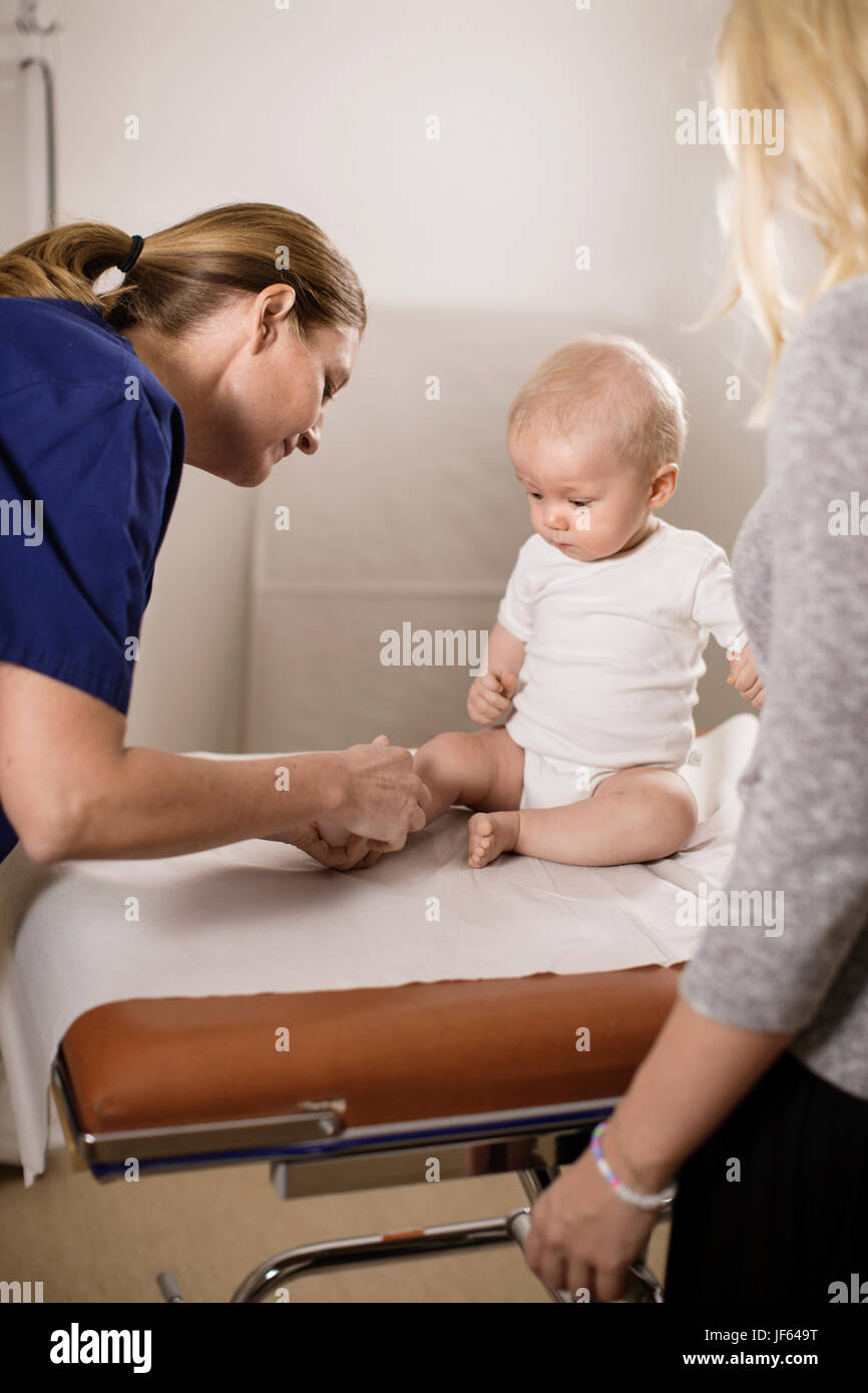 Doctor checking baby Stock Photo - Alamy