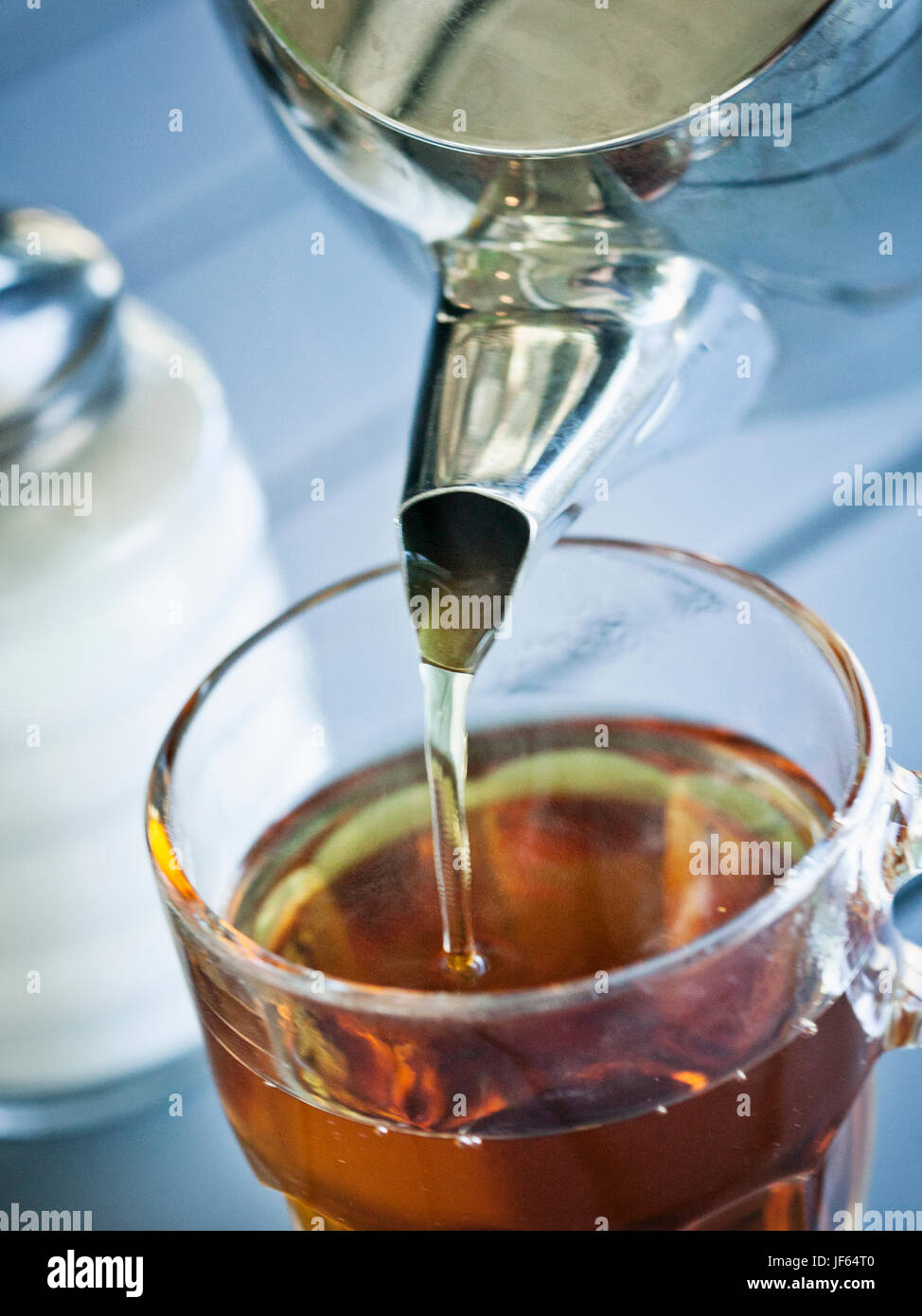 Pouring tea from tea kettle Stock Photo - Alamy