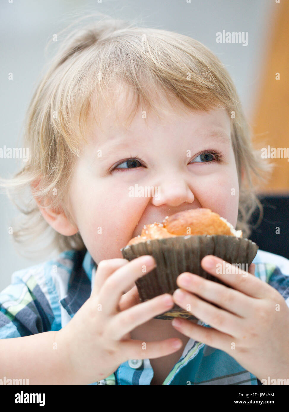 Little boy eating muffin Stock Photo - Alamy