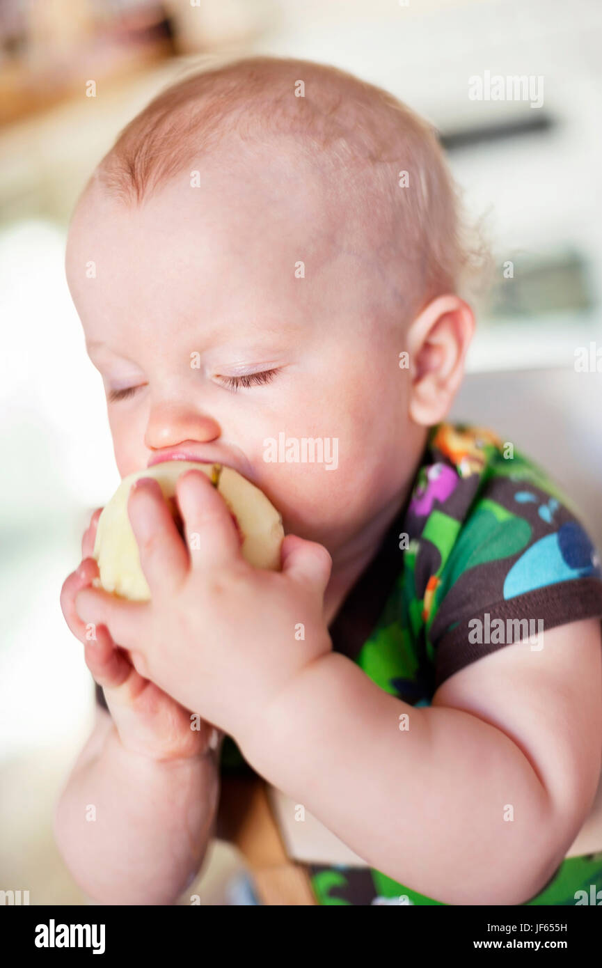 Baby boy eating apple Stock Photo - Alamy