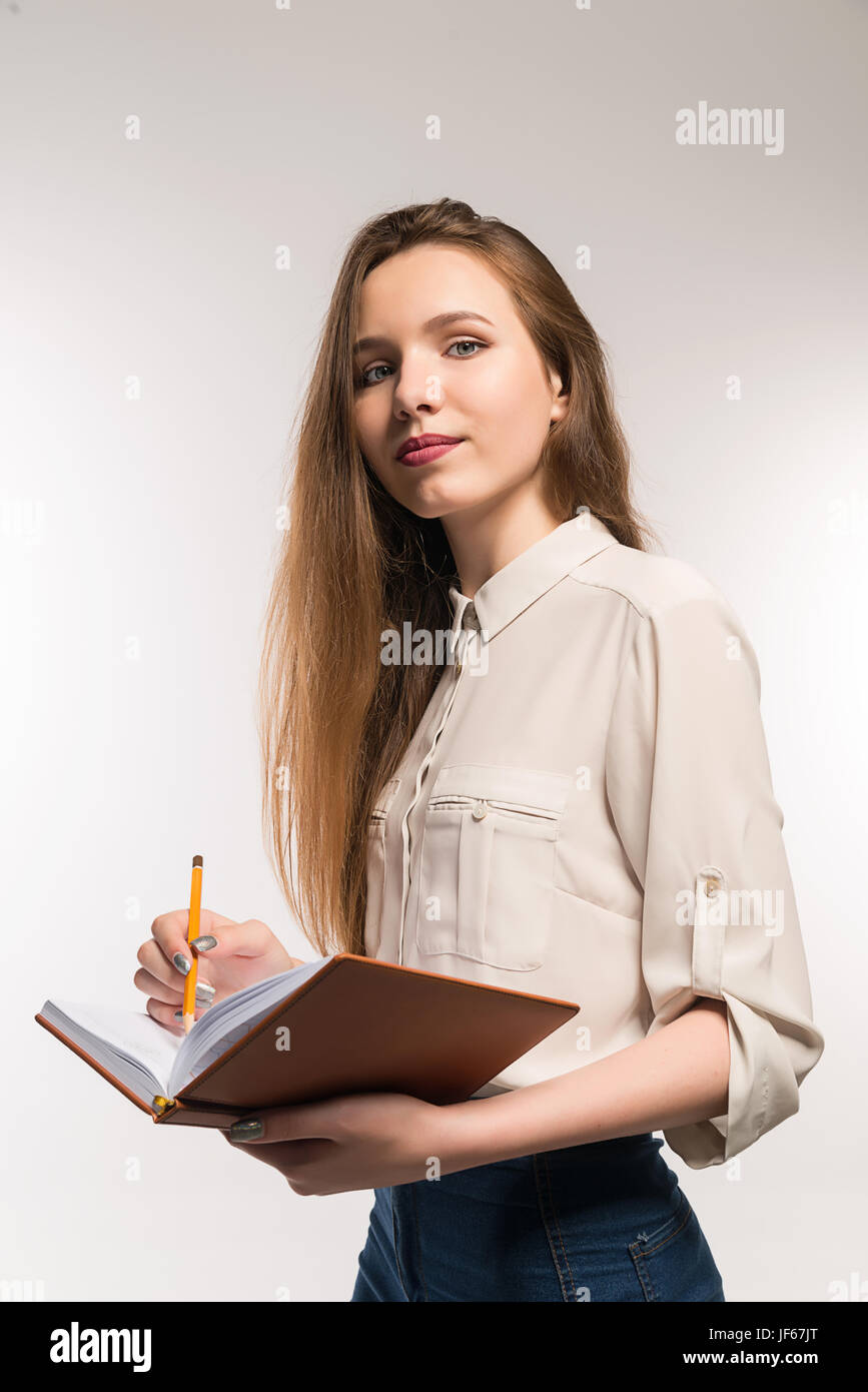 Girl with pencil and book in hands Stock Photo - Alamy