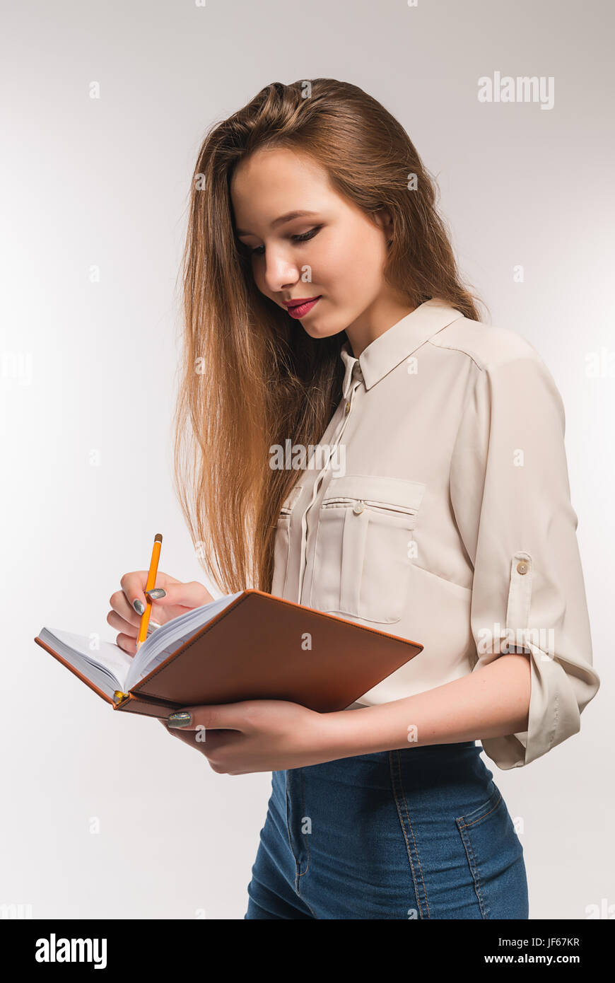 Girl with pencil and book in hands Stock Photo - Alamy