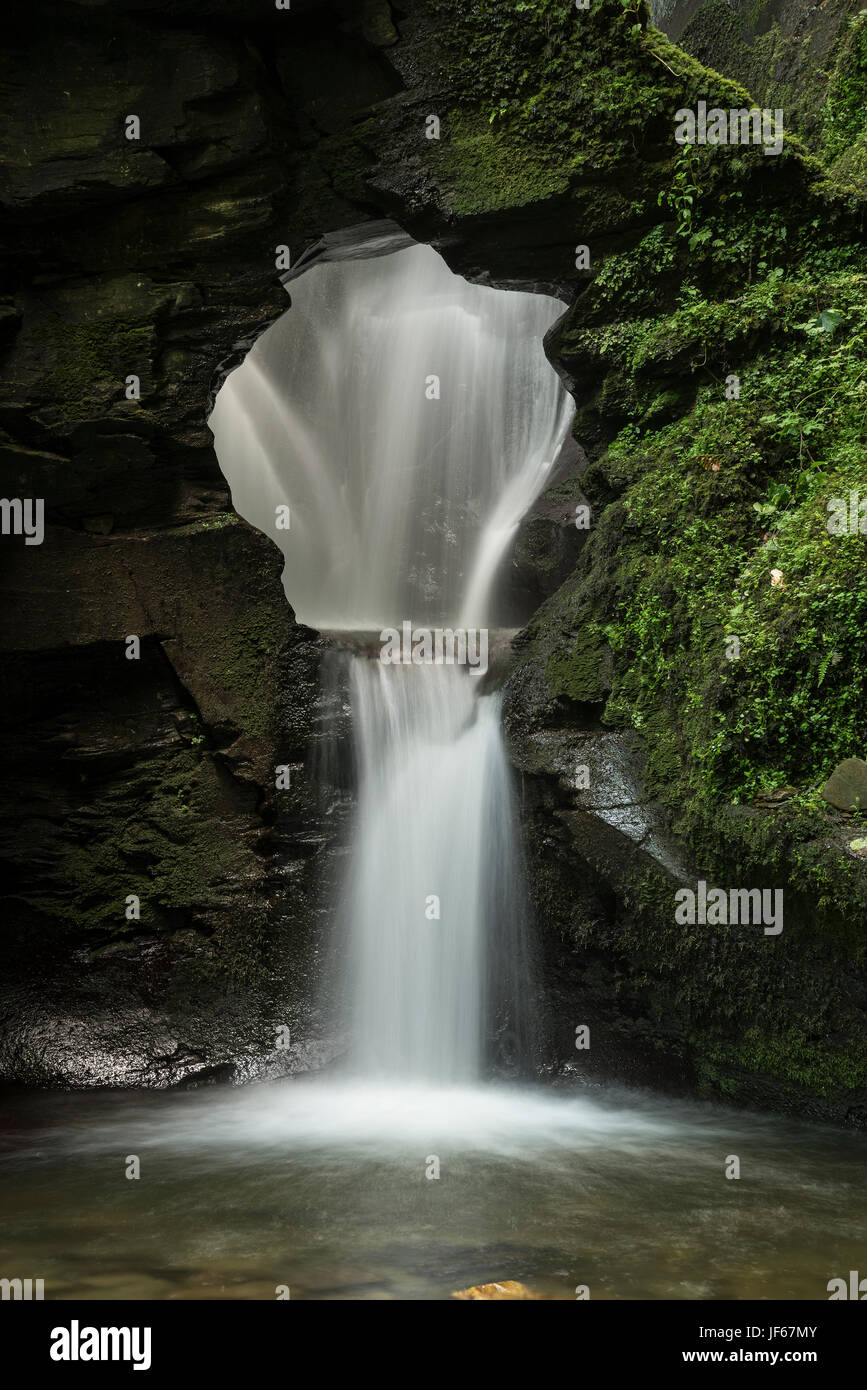 Beautiful flowing waterfall with magical fairy tale feel in lush green ...