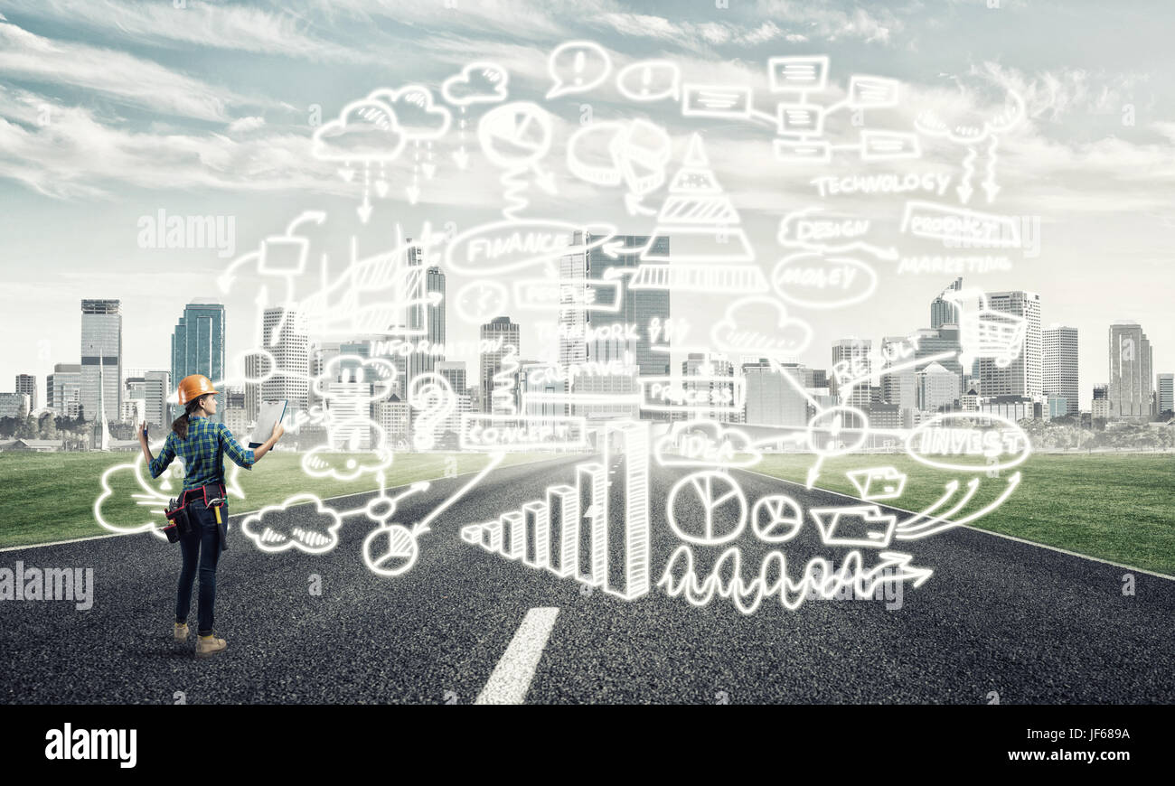 Back view of engineer woman in hardhat outdoor and sketched concept on ...